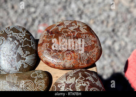 Souvenirs of Nazca lines carved into small rounded stones Stock Photo ...