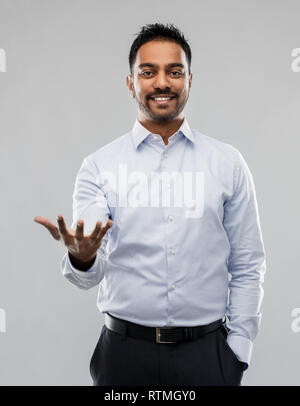 indian businessman holding something invisible Stock Photo - Alamy