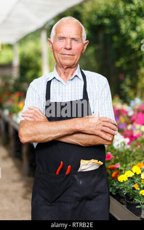 Portrait of older man proud of blooming flowers cultivated in his ...
