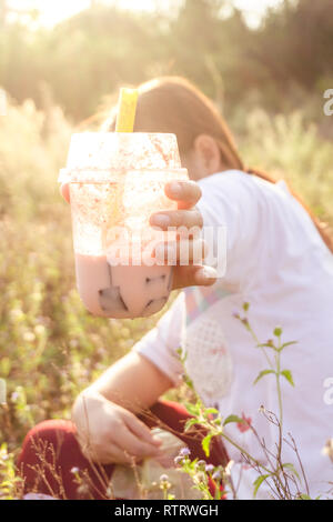 Drink Boba Tea in the grassland, sunset light Stock Photo - Alamy