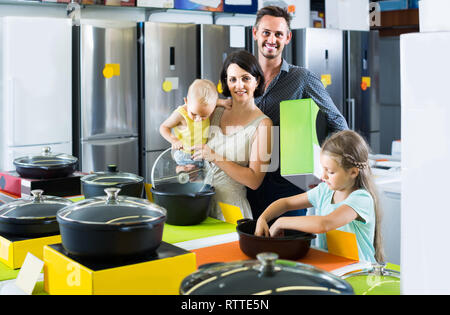 parents with two kids choosing kitchenware in home appliance store ...