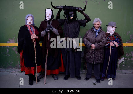 Revelers wearing traditional bull-head masks take part in the ...