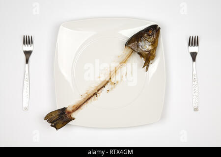 eaten fish with head and tail - symbol of misery Stock Photo - Alamy