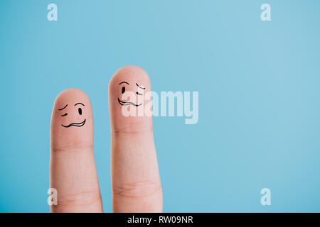 cropped view of fingers as frustrated people looking at drunk man ...