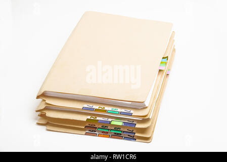 A stack of patient medical records in folders with color-coded and ...