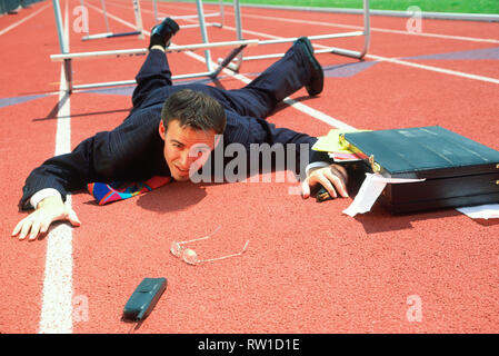 Young businessman fallen over hurdle on running track, USA Stock Photo ...