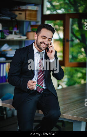 Woman designer sitting on brick stack in construction site and using ...