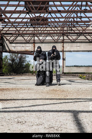 Special forces operators in black uniforms in action Stock Photo - Alamy