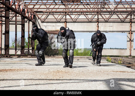 Special forces operators in black uniforms in action Stock Photo - Alamy