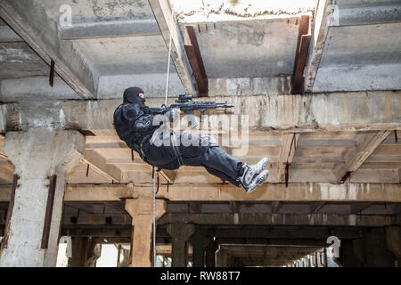 Special forces operator during assault rappelling with weapons Stock ...
