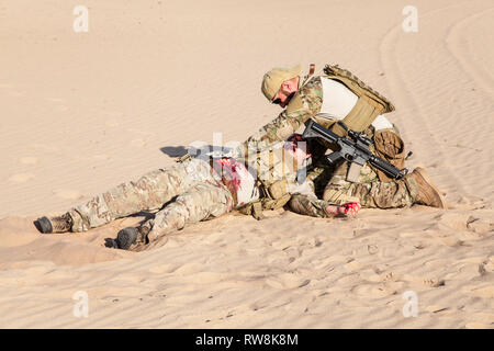 Medic in uniform helping injured man to walk, applying first aid after ...