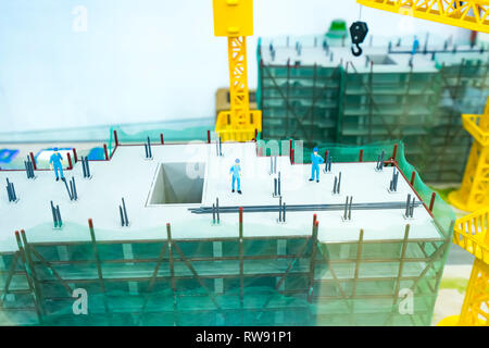Miniature scale model construction workers with an industrial electric ...