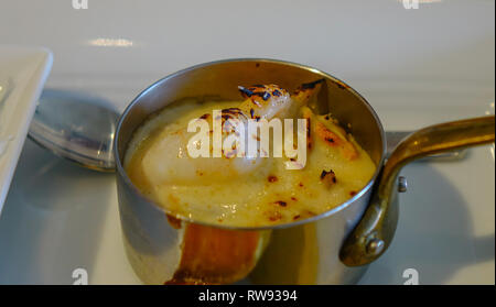 Seafood concet with mussels and cheese in bowl on white concrete ...