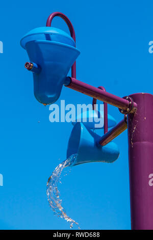 Blue plastic bucket dumping water at a water park Stock Photo - Alamy