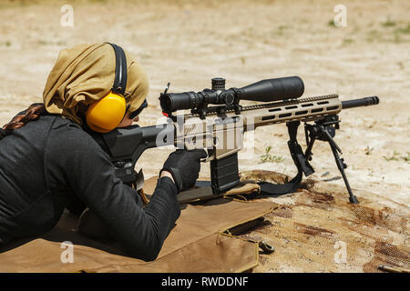Female army soldier shooting with sniper rifle. Woman with weapon ...