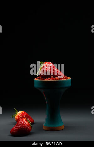 Hookah head with fruit on it decorated with exhaled smoke on black ...