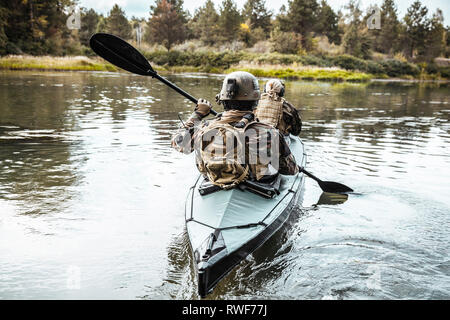Special forces men paddling Army kayak across the river Stock Photo - Alamy