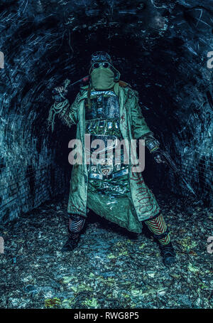 Post apocalyptic survivor holding a pistol and machete in an abandoned ...