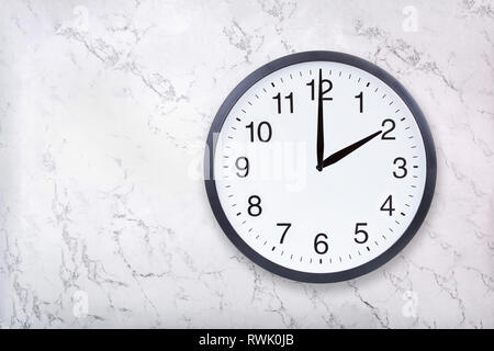 Wall clock show two o'clock on marble texture. Office clock show 2pm or ...