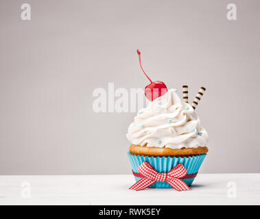 Blue cupcake on grey background with copy space Stock Photo - Alamy