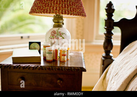 Alarm clock with pill bottles on table in room, closeup Stock Photo - Alamy