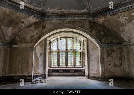 Arched door with broken windows in an old dilapidated Italian building ...