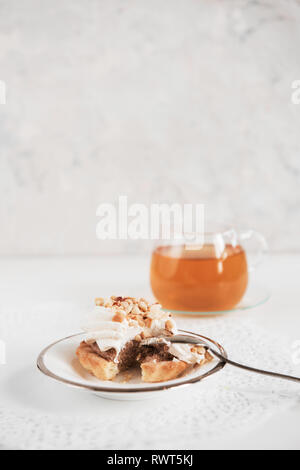 Blue and white ornate teapot with a teacup on a wooden table lit warmly ...