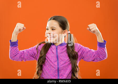 Feeling strong. Child cute girl show biceps power and strength. Girls ...