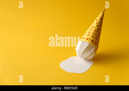 Melted paper vanila ice-cream cone on blue background. Copy space ...