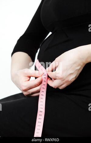 Pregnant woman holding meter tape on her baby bump Stock Photo - Alamy