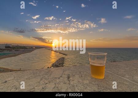 Glass of beer over a wall during sunset Stock Photo - Alamy