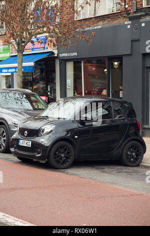 Smart car parked side ways / sideways, so at 90 degrees to the pavement ...