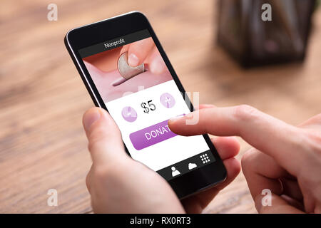 Mobile phone with "donate" on its screen Stock Photo - Alamy