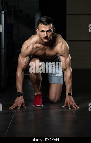 Strong Muscular Men Kneeling On The Floor - Almost Like Sprinter ...