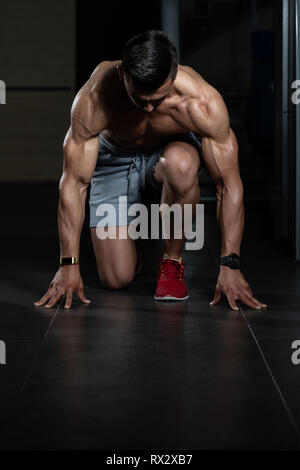 Strong Muscular Men Kneeling On The Floor - Almost Like Sprinter ...