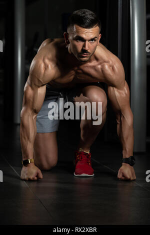 Strong Muscular Men Kneeling On The Floor - Almost Like Sprinter ...