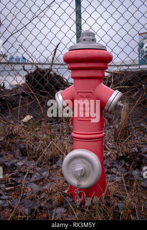 A metal fire hydrant stands in front of a commercial building in a ...