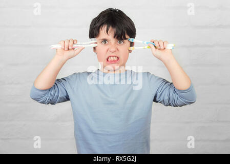 Portrait of sad unhappy boy who stands alone in snowy field holds ...