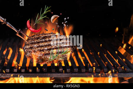 Flying beef steaks on grill with Fire flames. Isolated on black ...