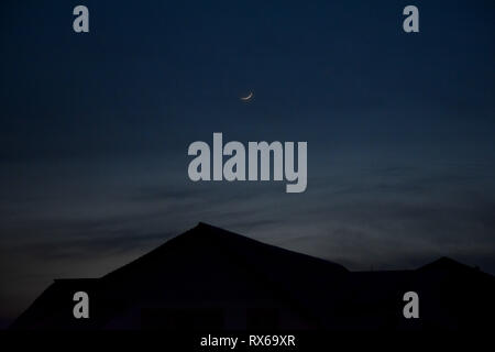 The crescent moon or Ramadan moon rises over the sky on the first day ...