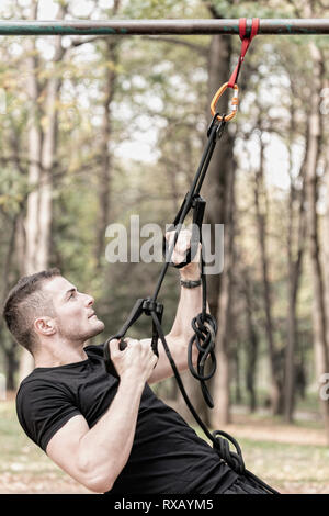 Caucasian man exercising with suspension training trx Stock Photo - Alamy