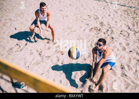 Four people playing beach volleyball for fun at Coogee beach a woman in ...