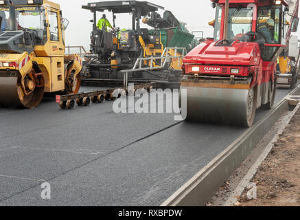 Asphalt paving machines working in echelon formation during the ...