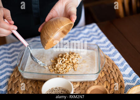 chef at work, making baked oatmeal with banana, blueberries, walnut and ...