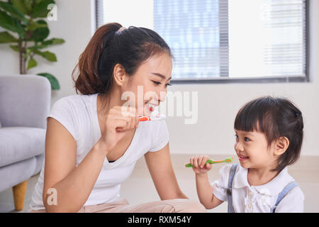 Mother teaching asian girl use toothbrush to clean, suffers from pain ...