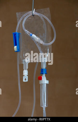 Close up of intravenous line attached to patient hand in hospital bed ...