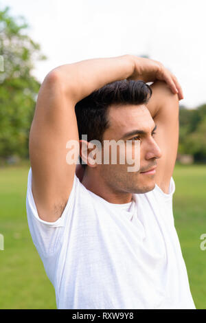 Young hispanic man stretching head standing at sport center Stock Photo ...