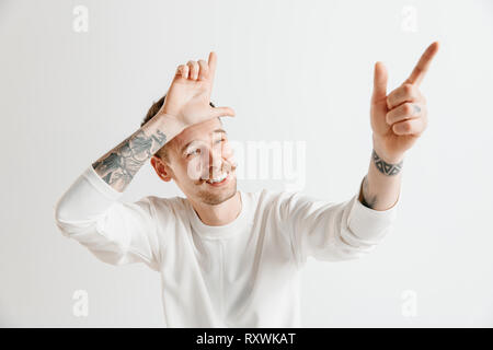 Losers go home. Portrait of happy guy showing loser sign over forehead ...