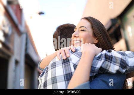 Happy couple of friends meeting and hugging in the street Stock Photo ...