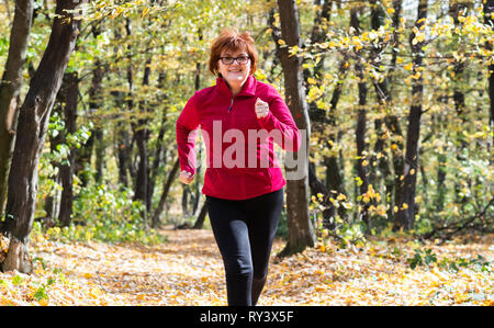 Middle age woman wearing sportswear holding red heart smiling happy ...